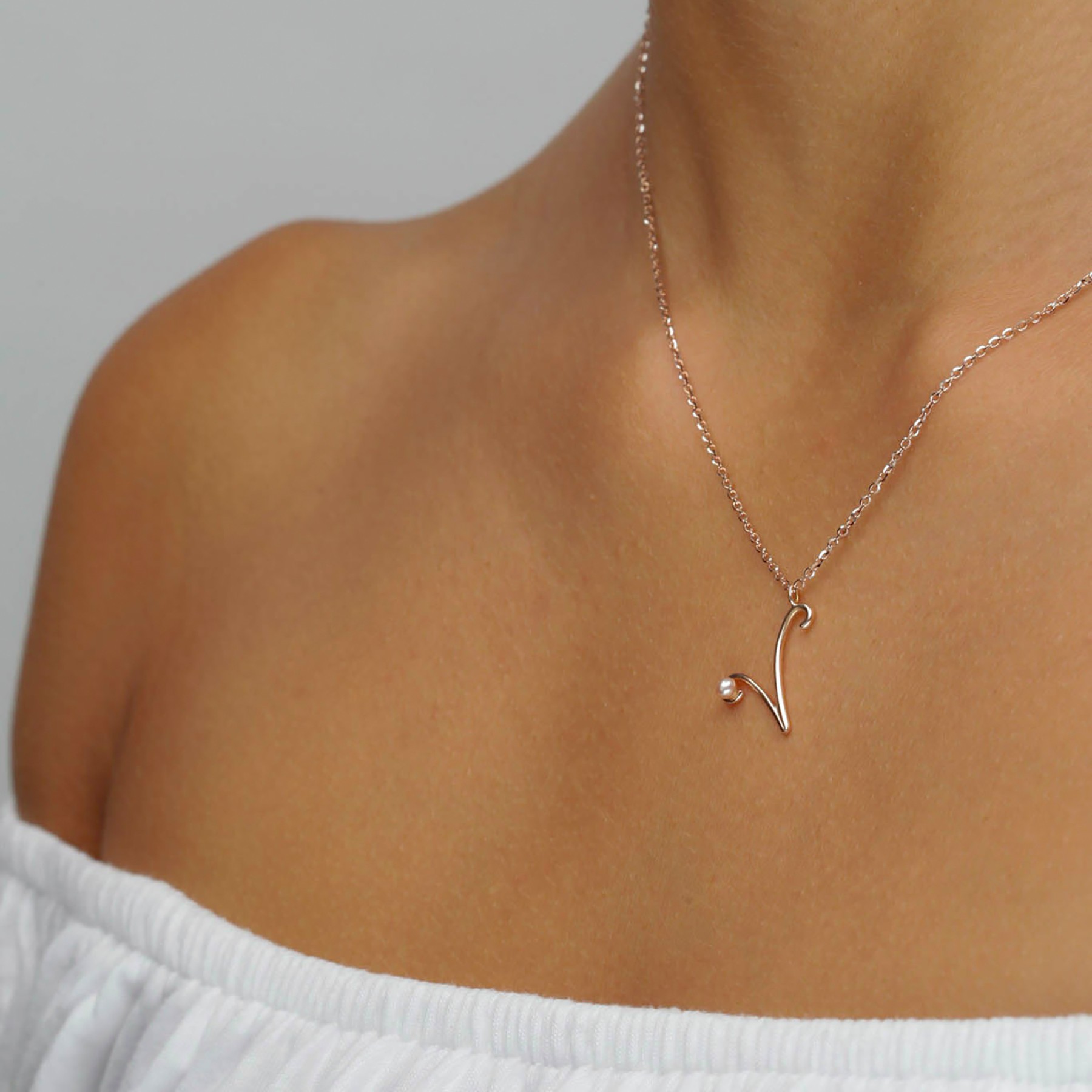 Letter V pendant made of 18-carat rose gold with natural pearl. Le